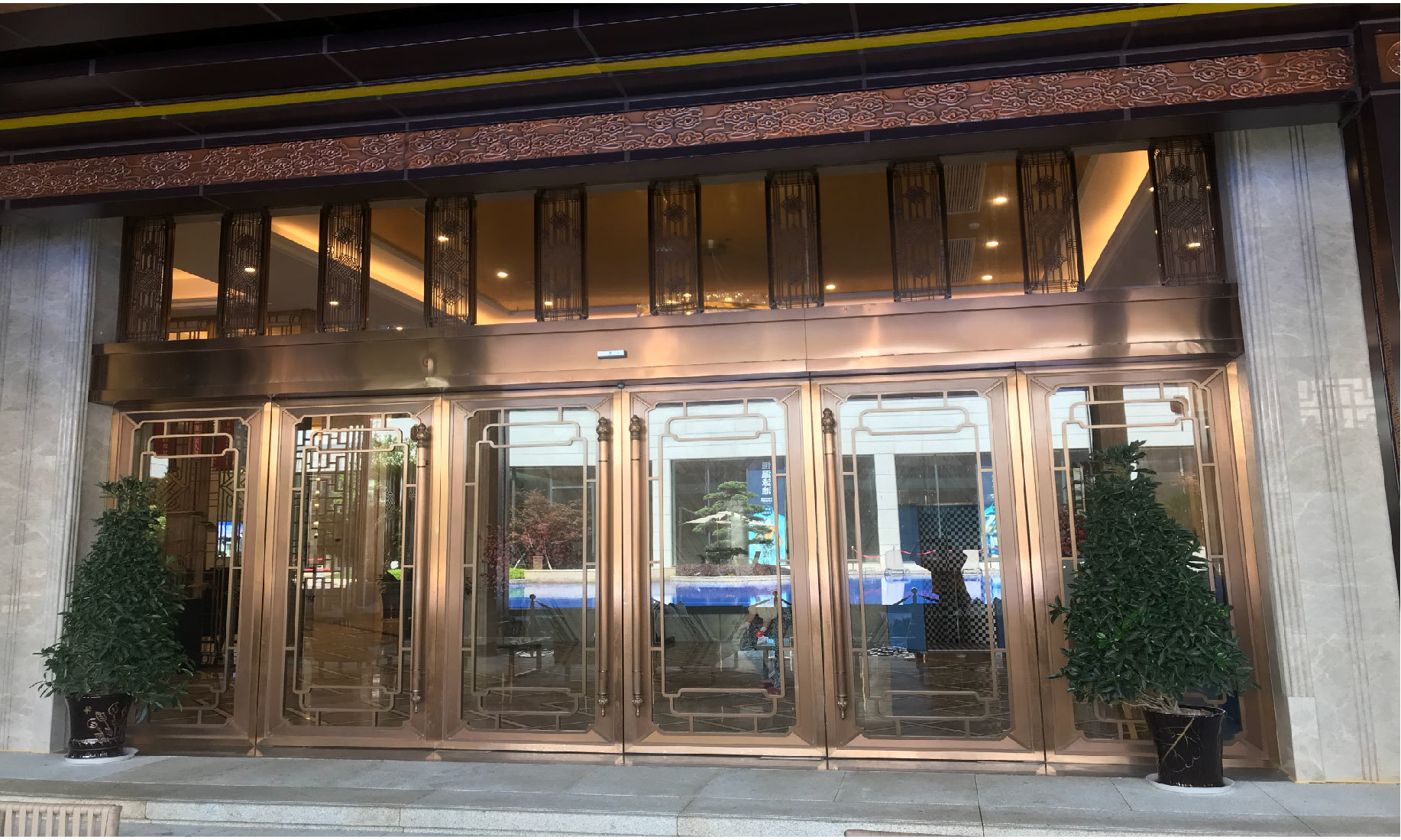 Modern Chinese-style building entrance with metal door frames and decorative metal detailing